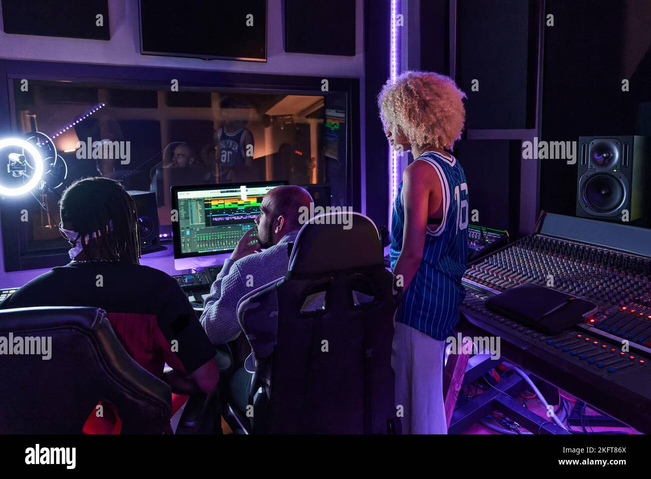 Back view of diverse people gathering in modern recording studio with ...