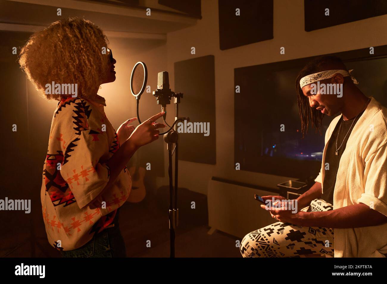 Side view of African American man using smartphone while sitting on ...