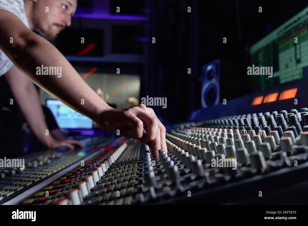 Crop male sound engineer using mixer console editing sounds in studio ...