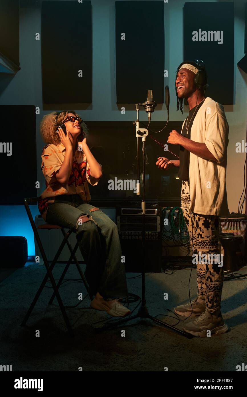 Full body of young African American male singer standing in studio ...