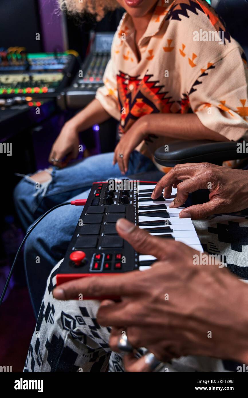 Positive cropped unrecognizable African American man playing music on ...