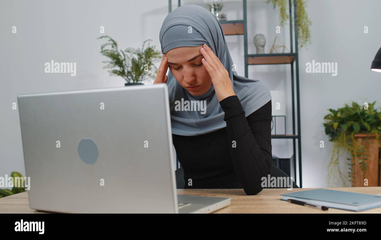 Tired muslim business woman in hijab use laptop suffering from headache ...