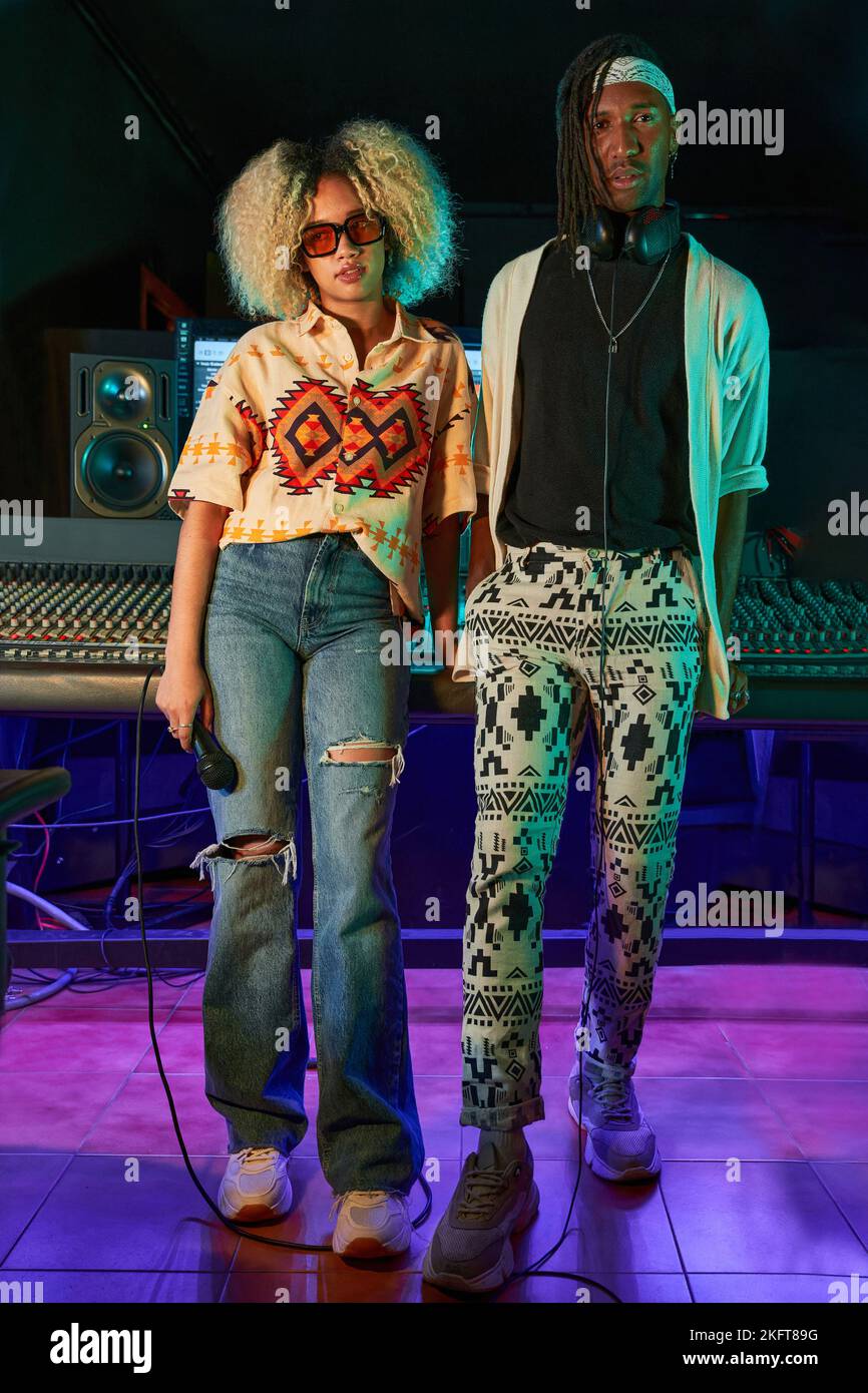 Full body of confident multiethnic partners in trendy outfits standing ...