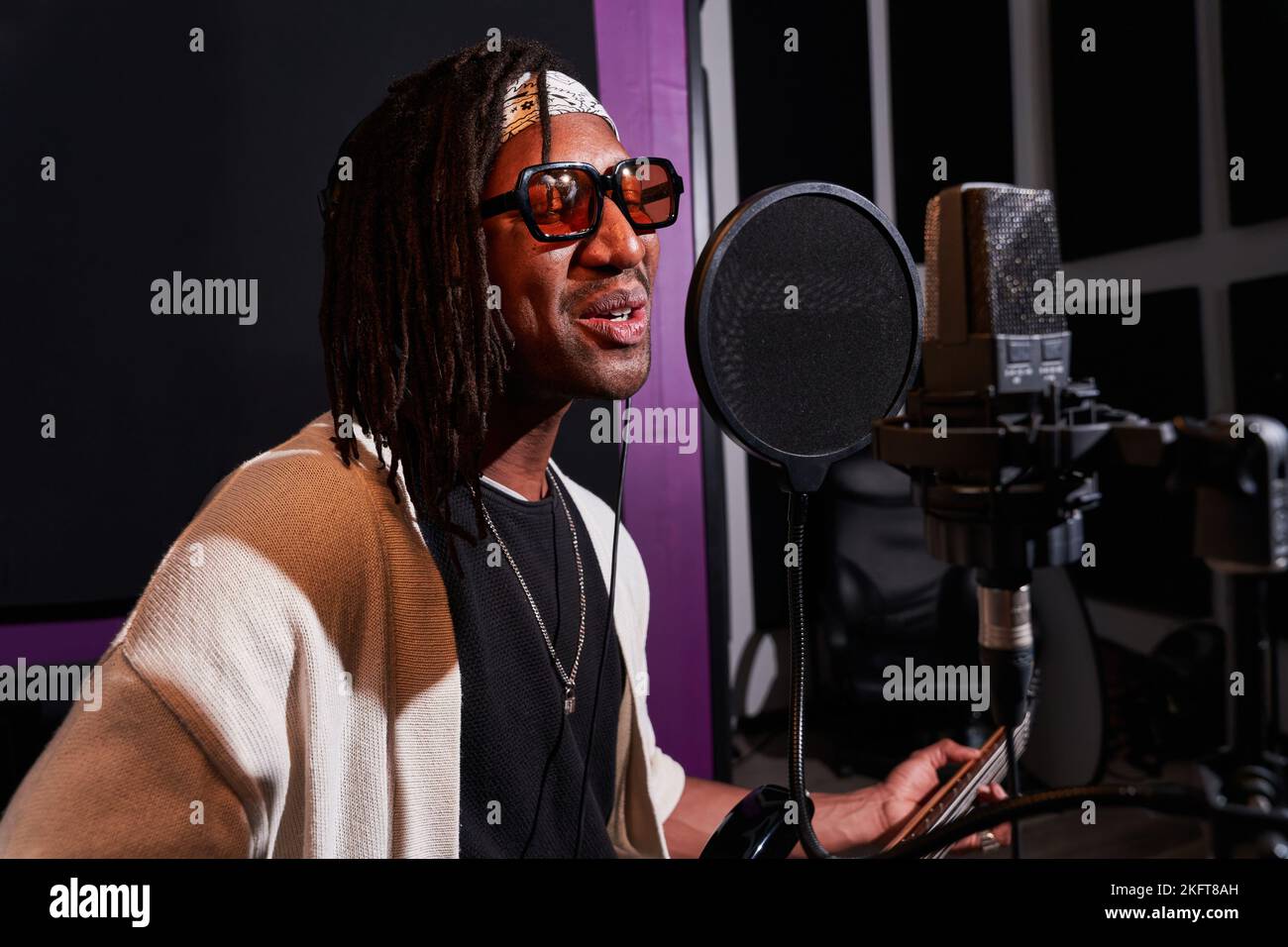 African American male musician with dreadlocks playing electric guitar ...