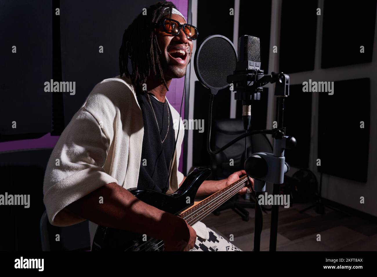 African American male musician with dreadlocks playing electric guitar ...