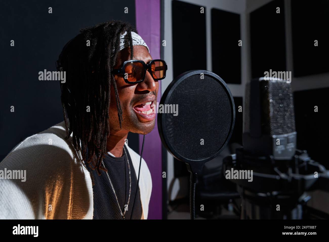 Side view of African American male singer in headphones and sunglasses ...