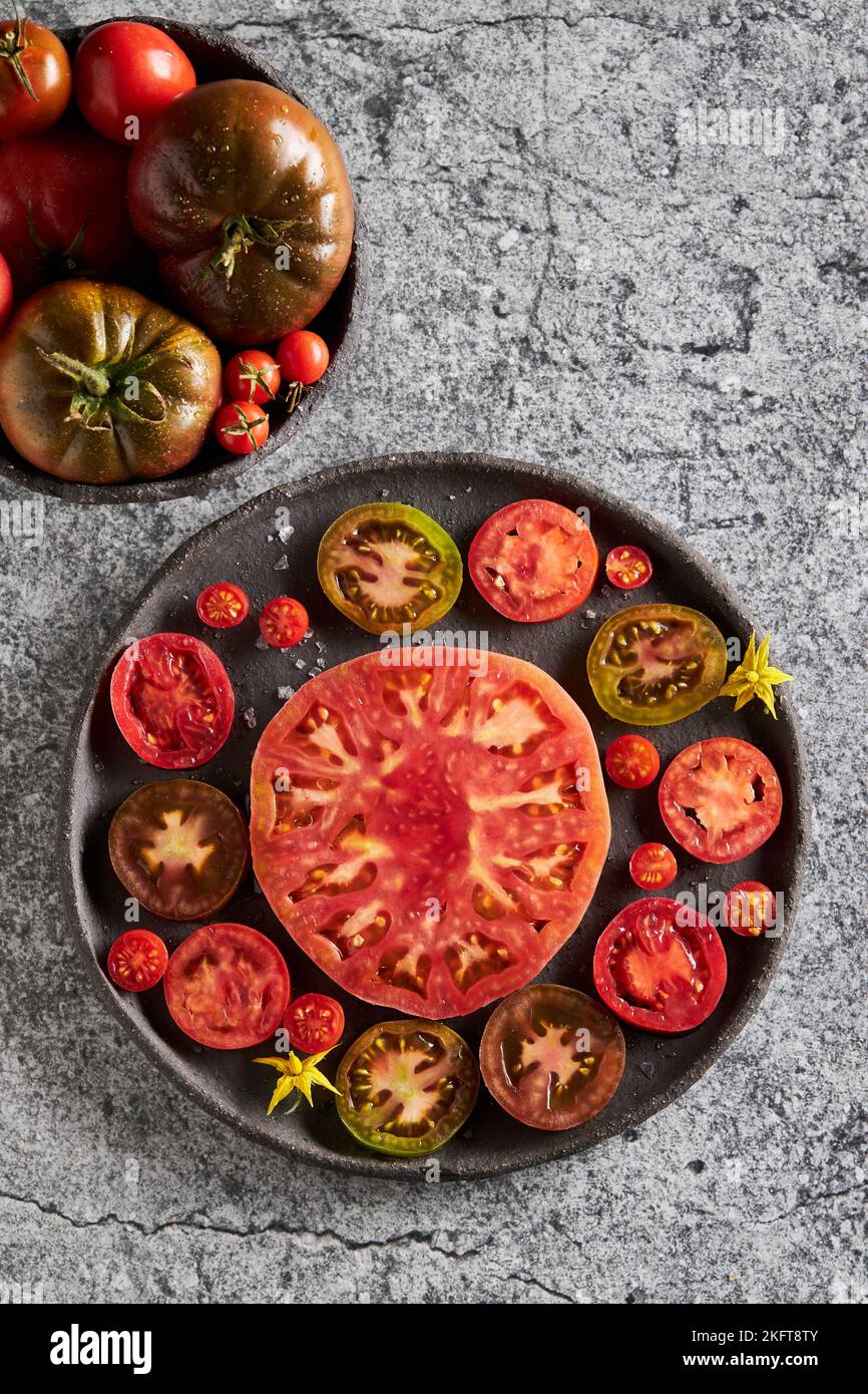 Top view of delicious sliced tomatoes in cast iron plate placed on ...