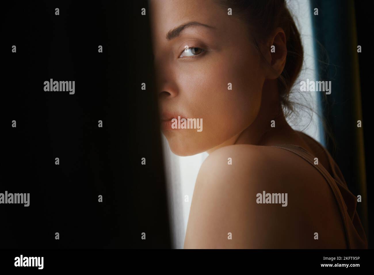 Side view of Pensive woman relaxing next to the window Stock Photo - Alamy