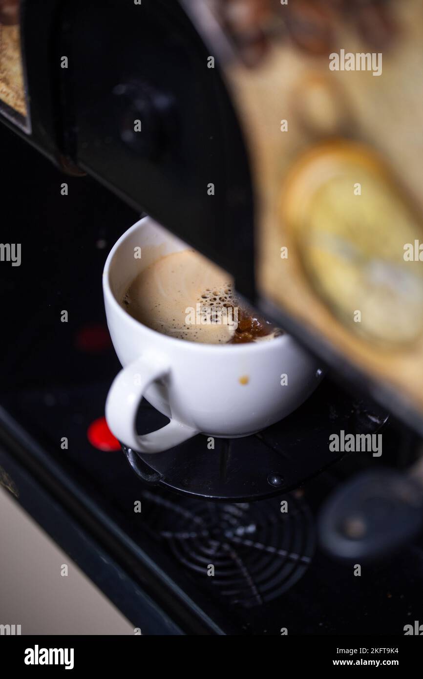 a white cup in a coffee machine in the process of making coffee Stock ...