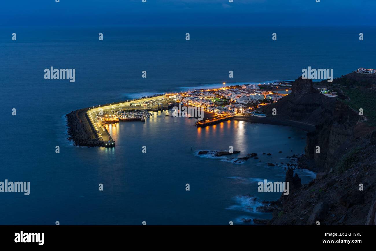 An aerial shot of buildings on the coast of an ocean surrounded by a ...