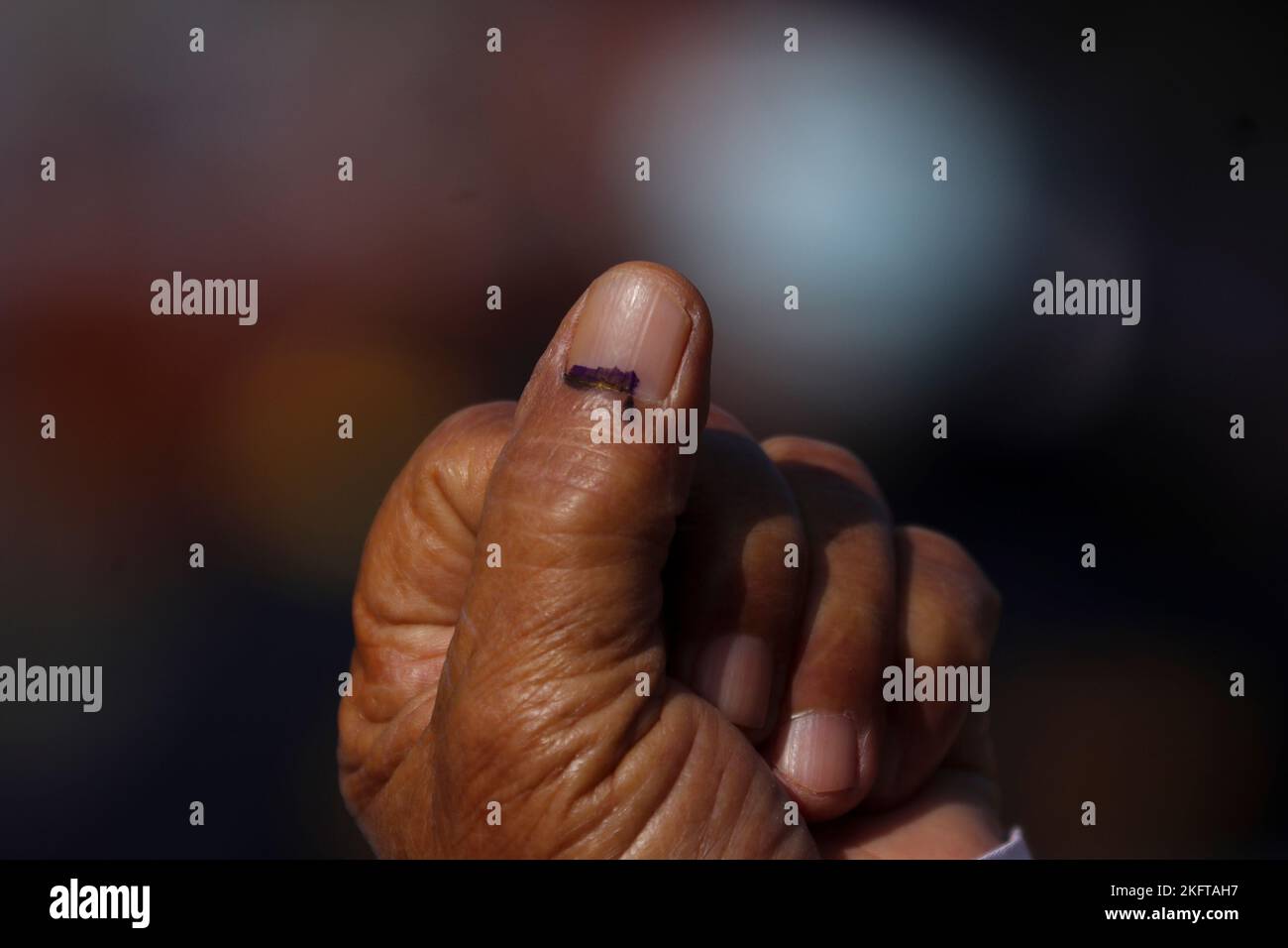 Kathmandu, NE, Nepal. 20th Nov, 2022. A man shows an ink-marked finger ...