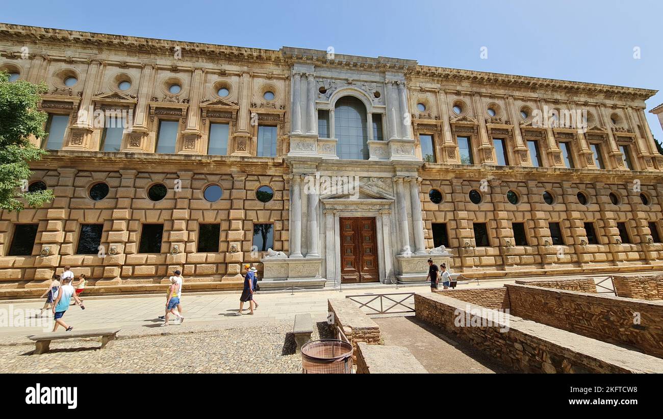 A low angle shot of people walking against the Alhambra castle in ...
