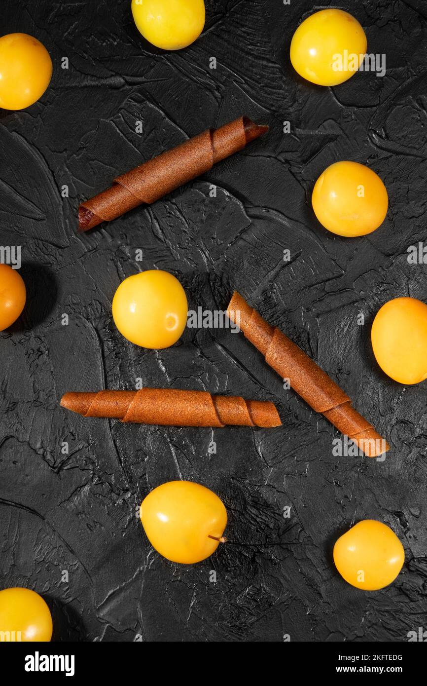 Pastila fruit skin rolls with fruits on a black background. Vegetarian ...