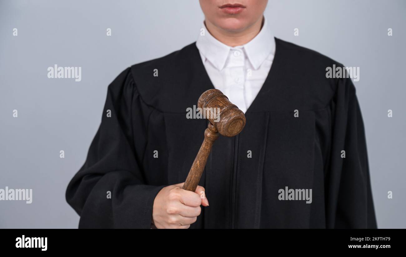 Faceless female judge in a robe holding a court gavel Stock Photo - Alamy