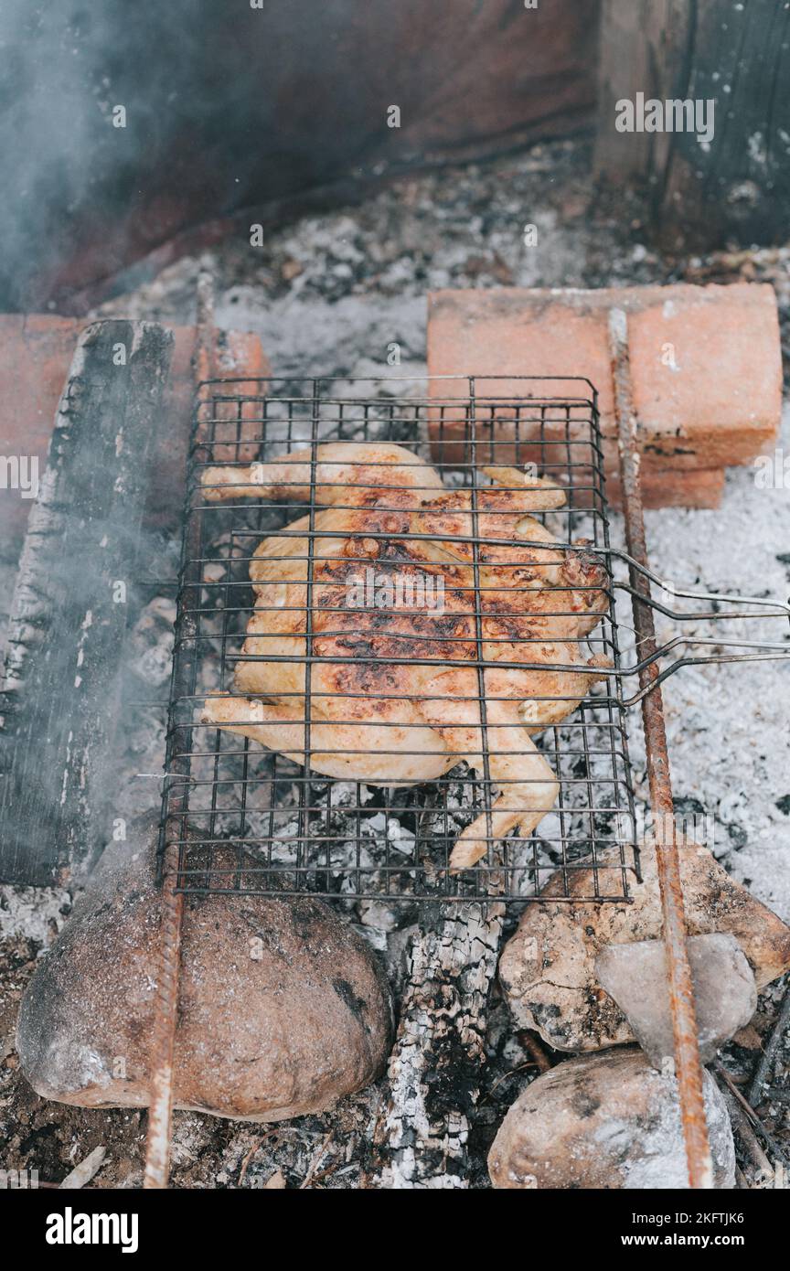 chicken meat food are fried on grill on smoldering coals or ember from ...