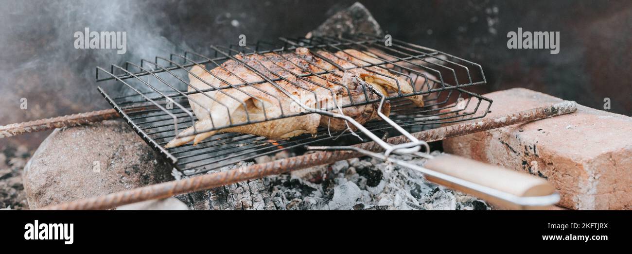 chicken meat food are fried on grill on smoldering coals or ember from ...
