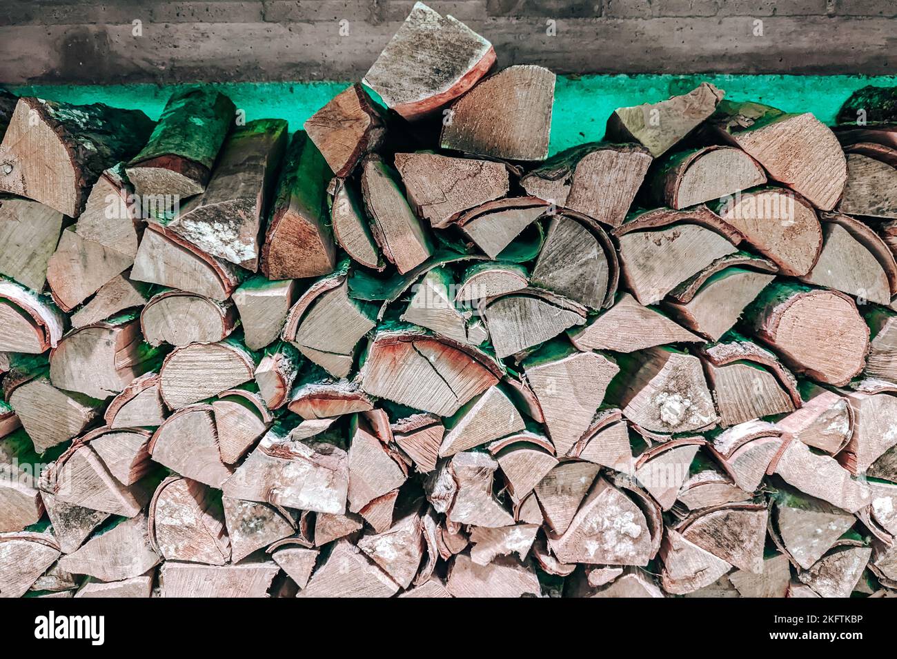 Dry chopped firewood logs in a pile indoors. Stack of firewood to fuel ...