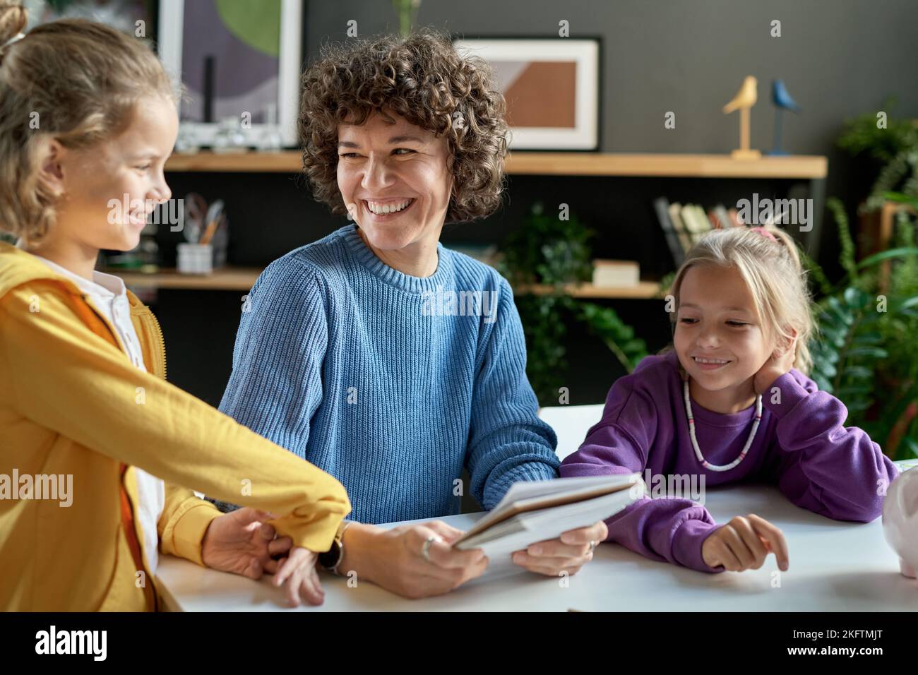 Happy mother laughing together with her children while they sitting at ...