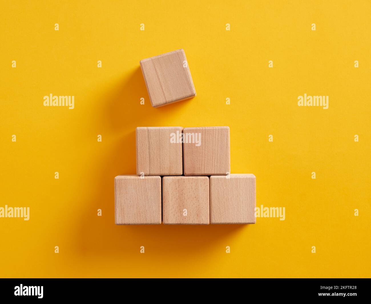 Pyramid of blank wooden cubes on yellow background Stock Photo - Alamy