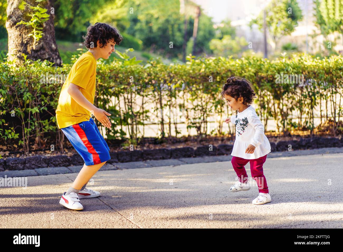 Happy brother boy and sister baby playing joyfully in the park ...