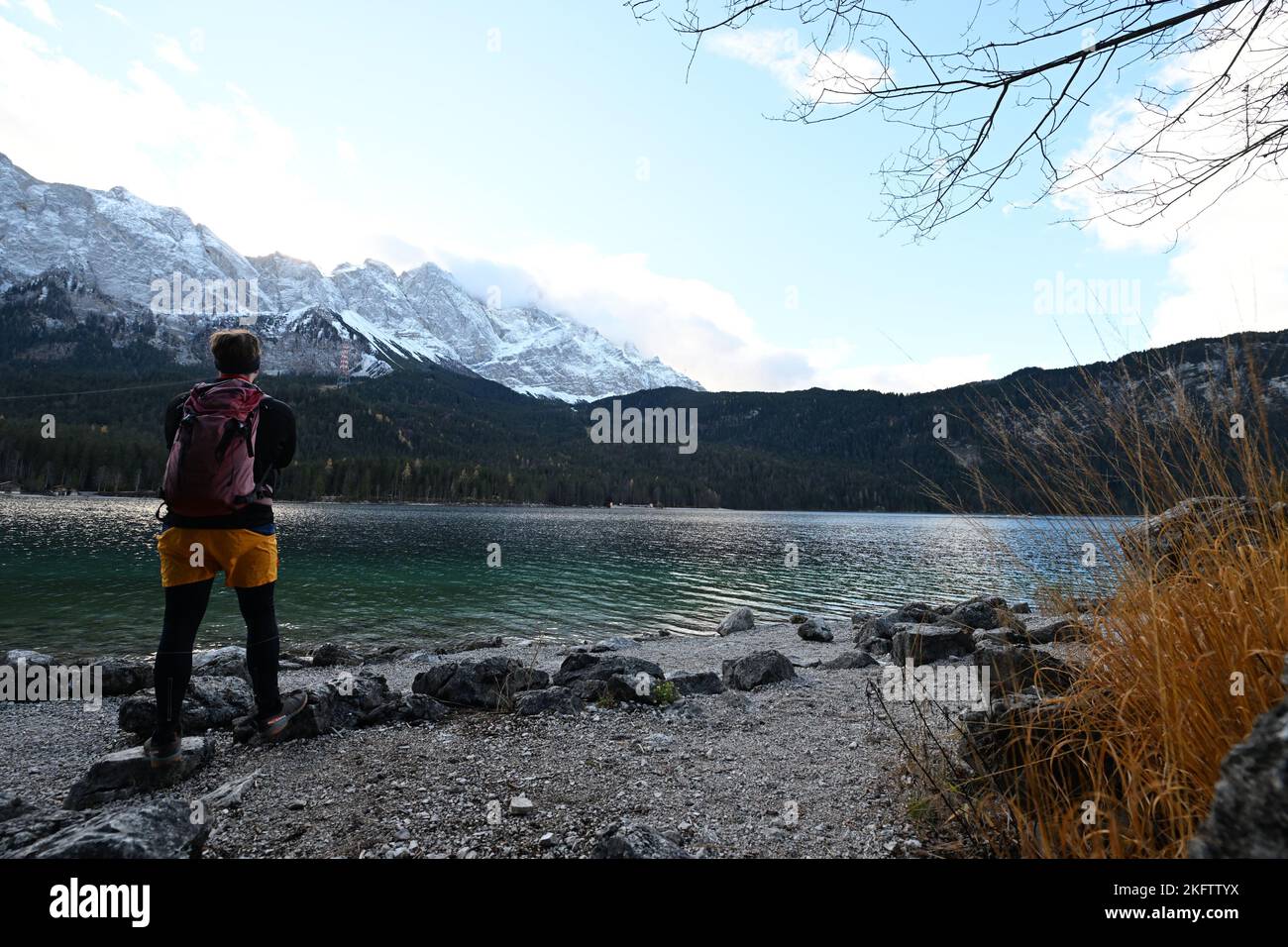 Grainau, Germany. 20th Nov, 2022. A hiker stands on the shore of the ...
