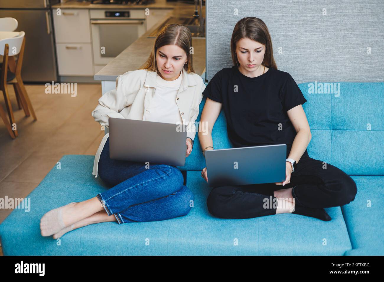 Two cute women are chatting with their friends via video call using a ...