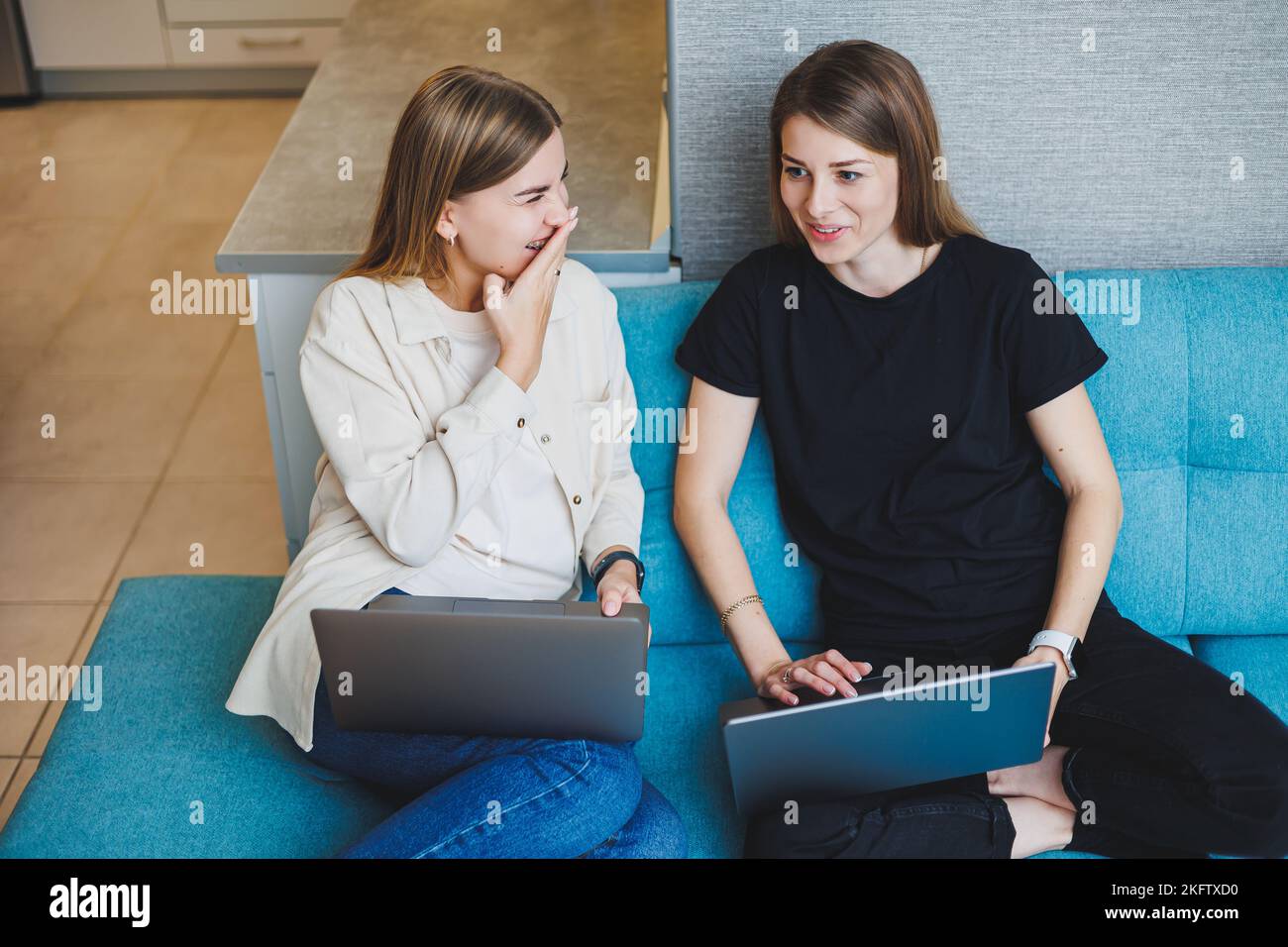 Two cute women are chatting with their friends via video call using a ...