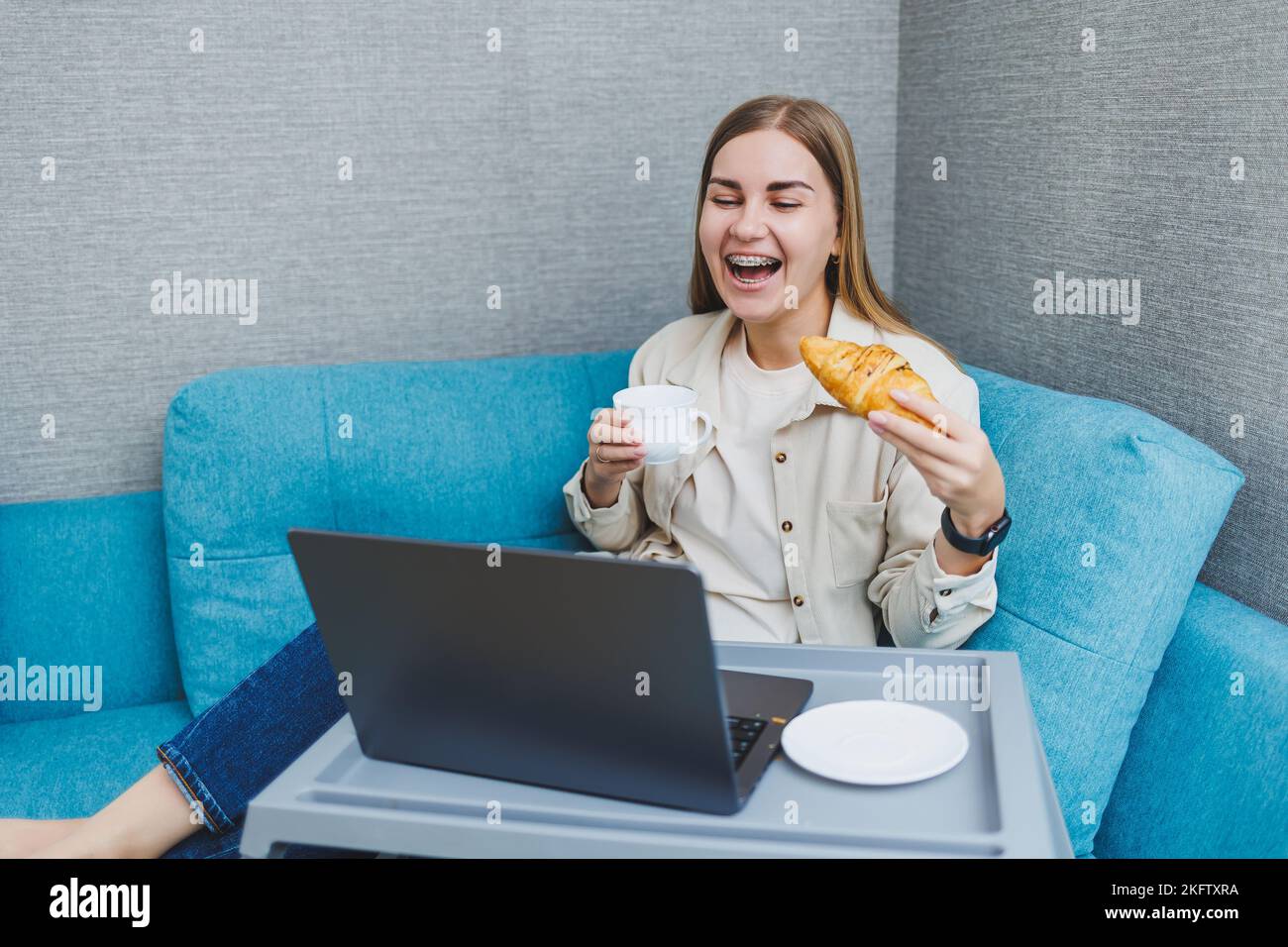 Young happy freelancer woman sitting on sofa working on project ...
