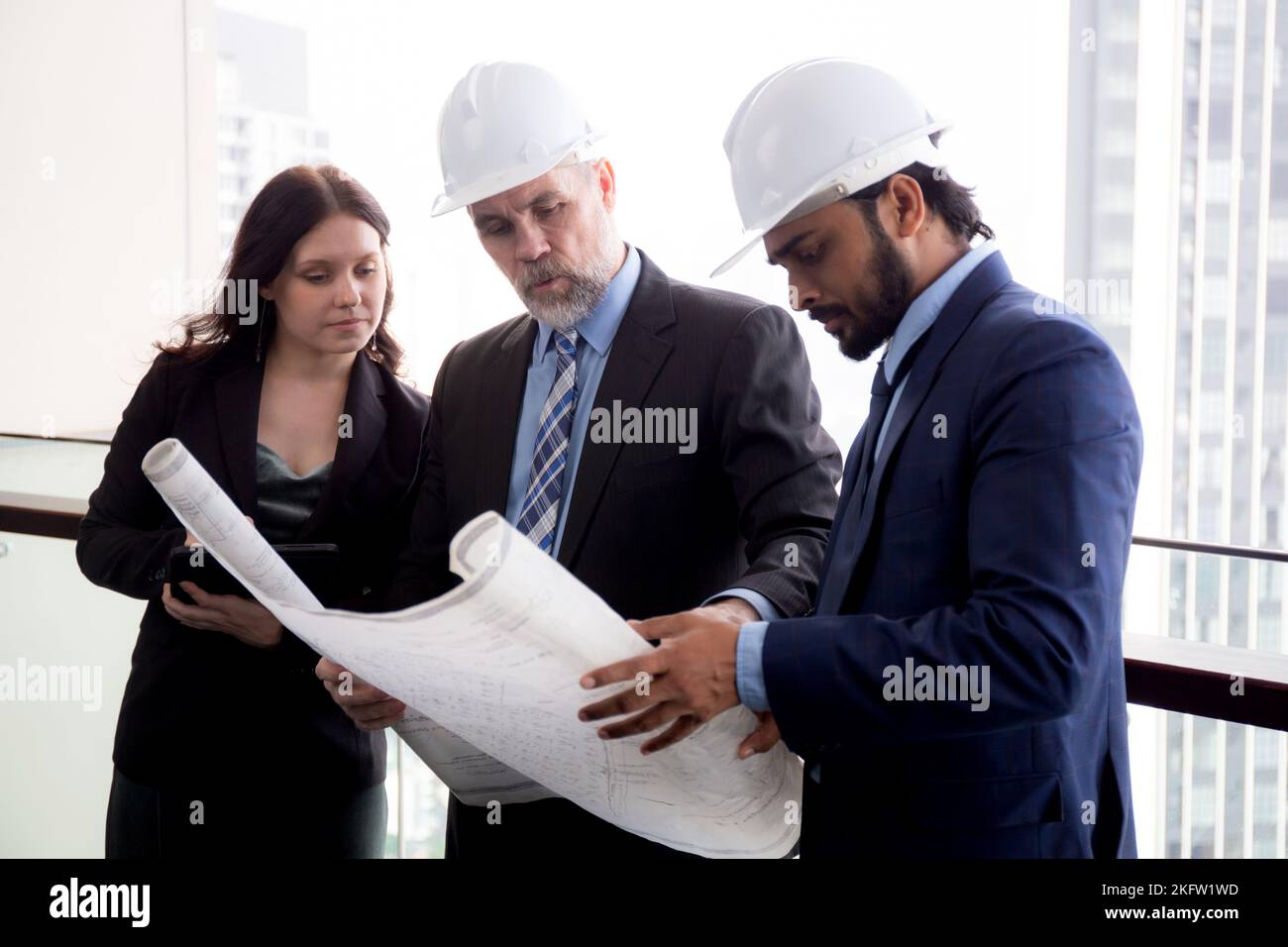Senior architect and secretary inspector check blueprint and structure ...