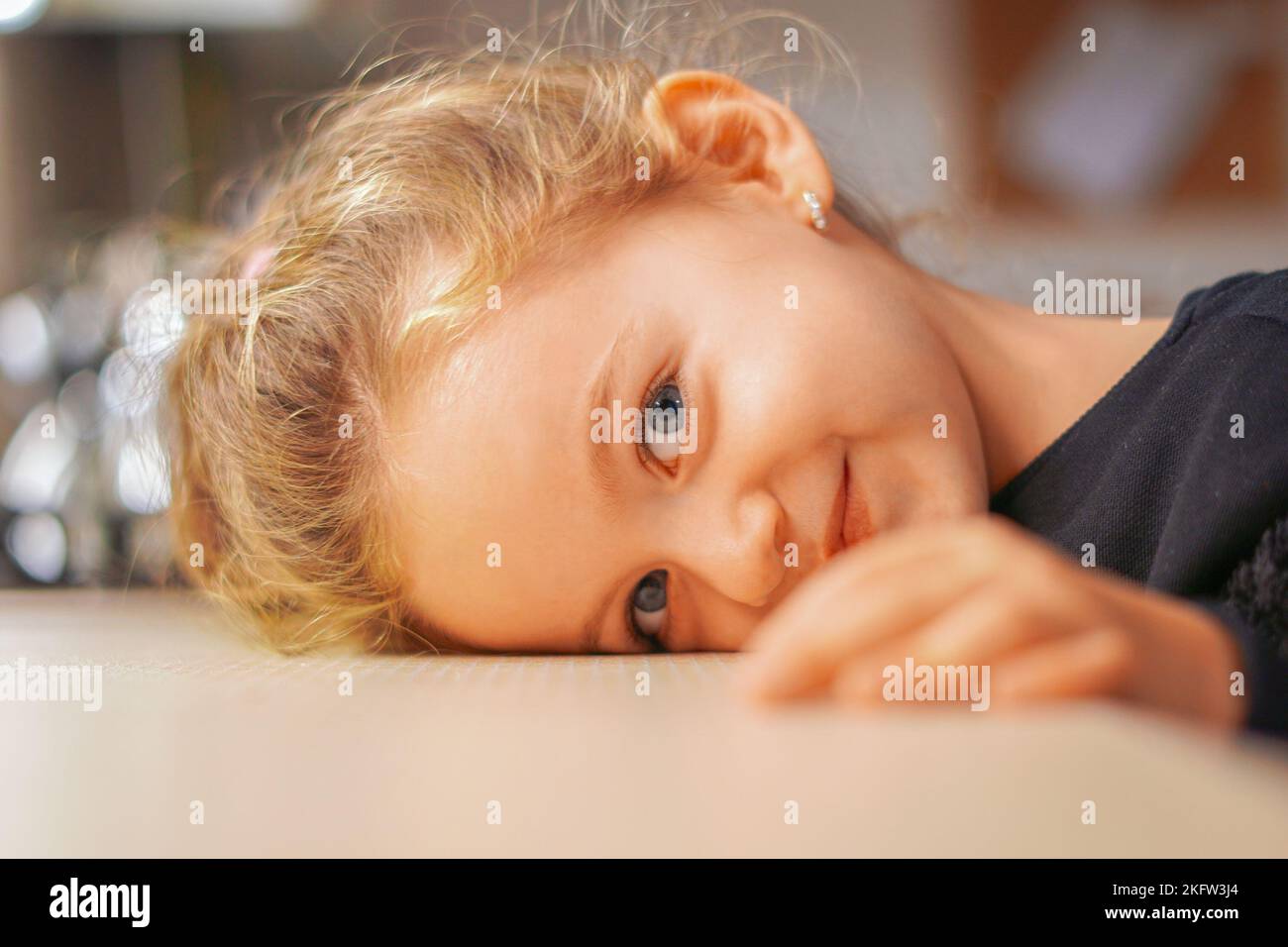Beautiful kid captured in a portrait smiling and lying down Stock Photo ...