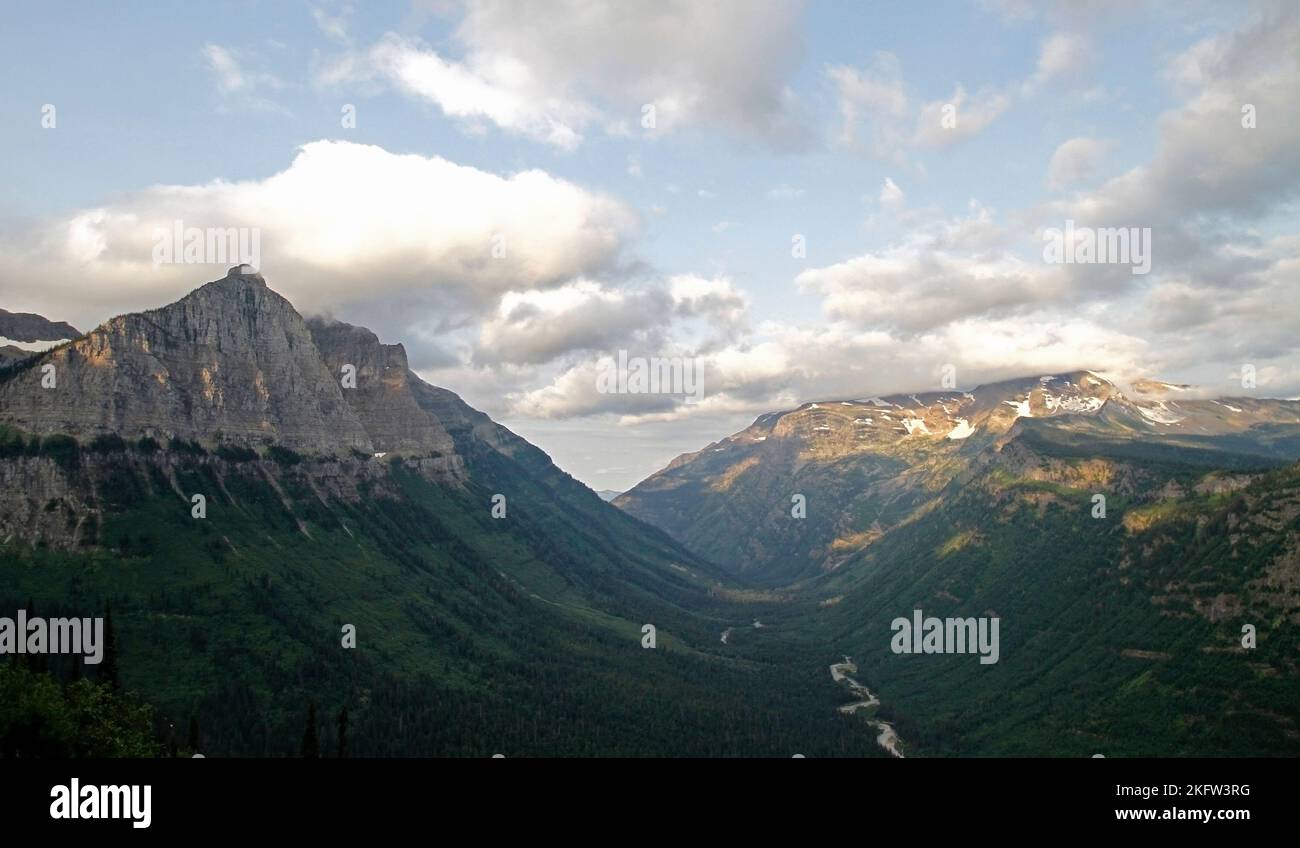 A beautiful scene of green mountains with snowy glacier under cloudy ...