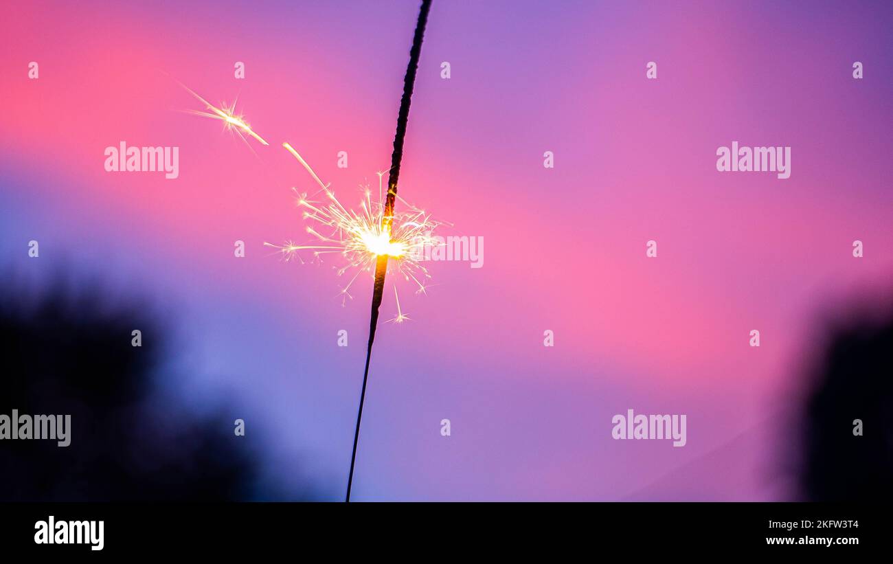 A shallow focus shot of a firecracker with blur pink sunset background ...