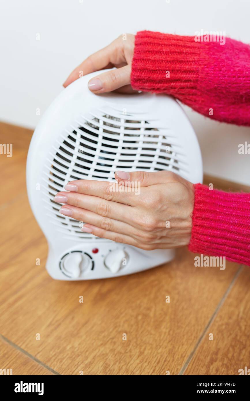 Woman warming herself heater hi-res stock photography and images - Alamy