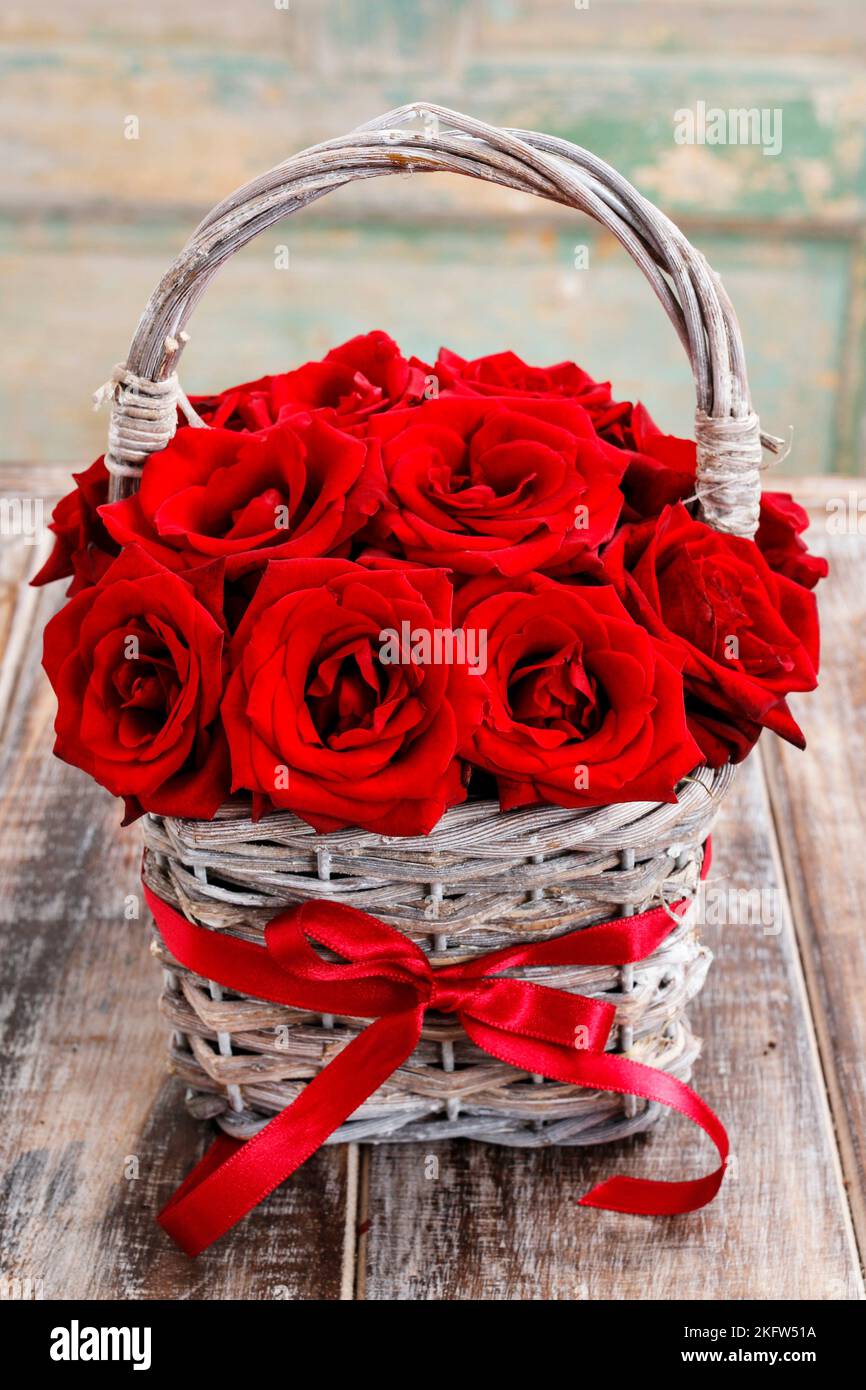 Bouquet of red roses in wicker basket. Party decor Stock Photo - Alamy