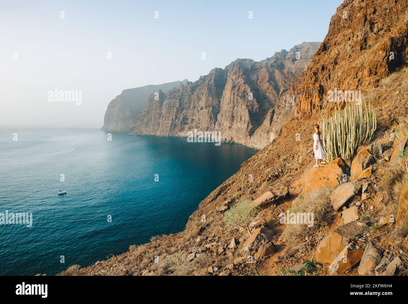 Landscape photo of a woman standing at the edge of big cliffs, the ...