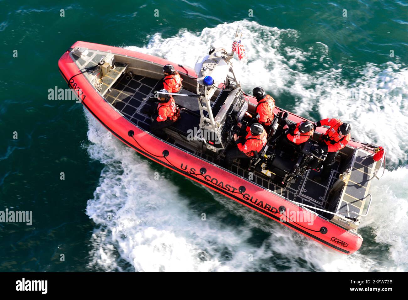 Crew members aboard an over-the-horizon cutter boat conduct operations ...