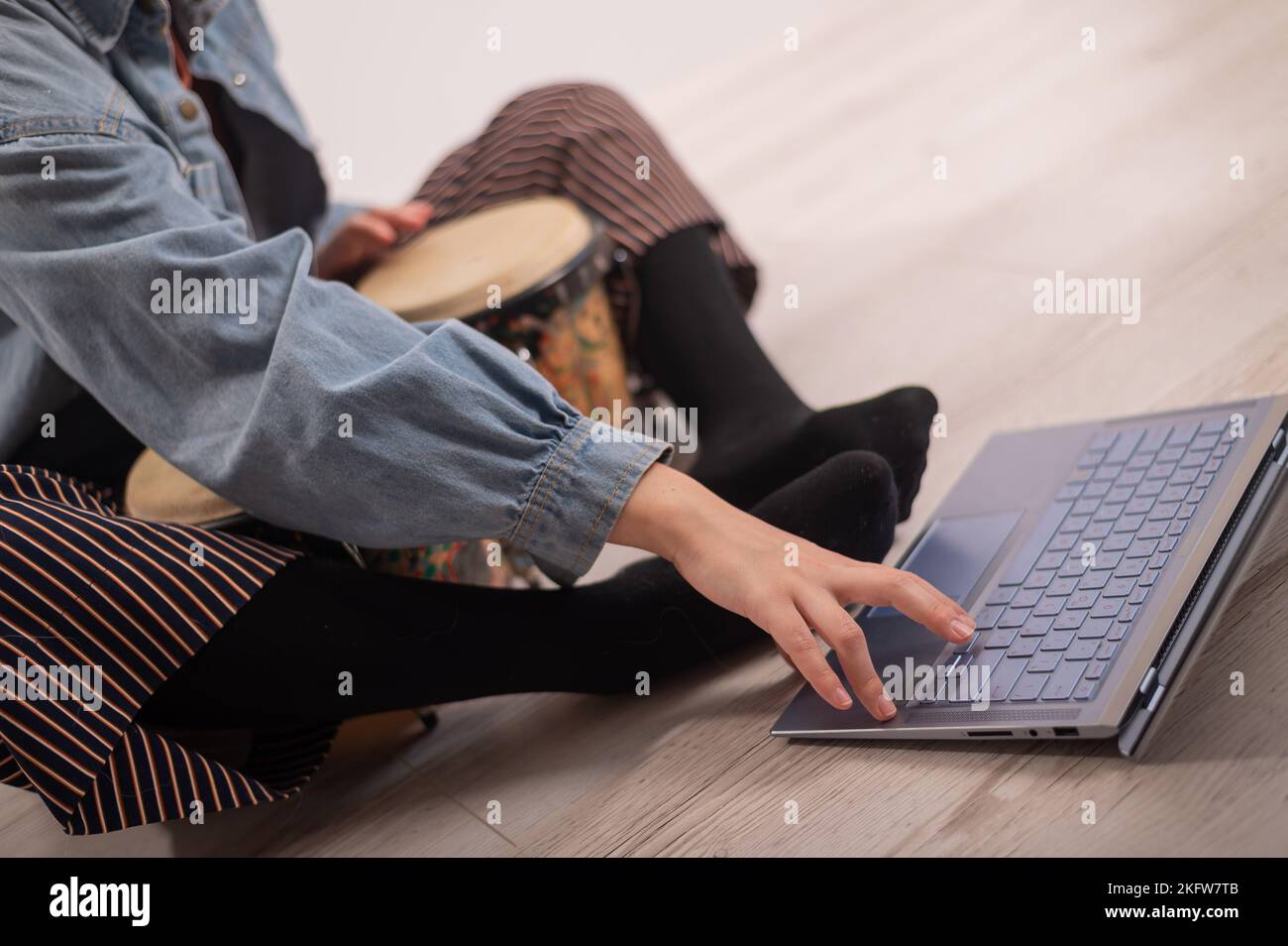 A faceless woman sits on the floor at home and watches educational ...