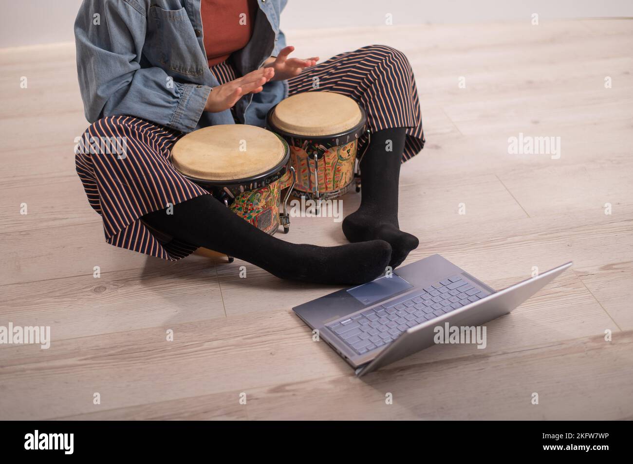 A faceless woman sits on the floor at home and watches educational ...
