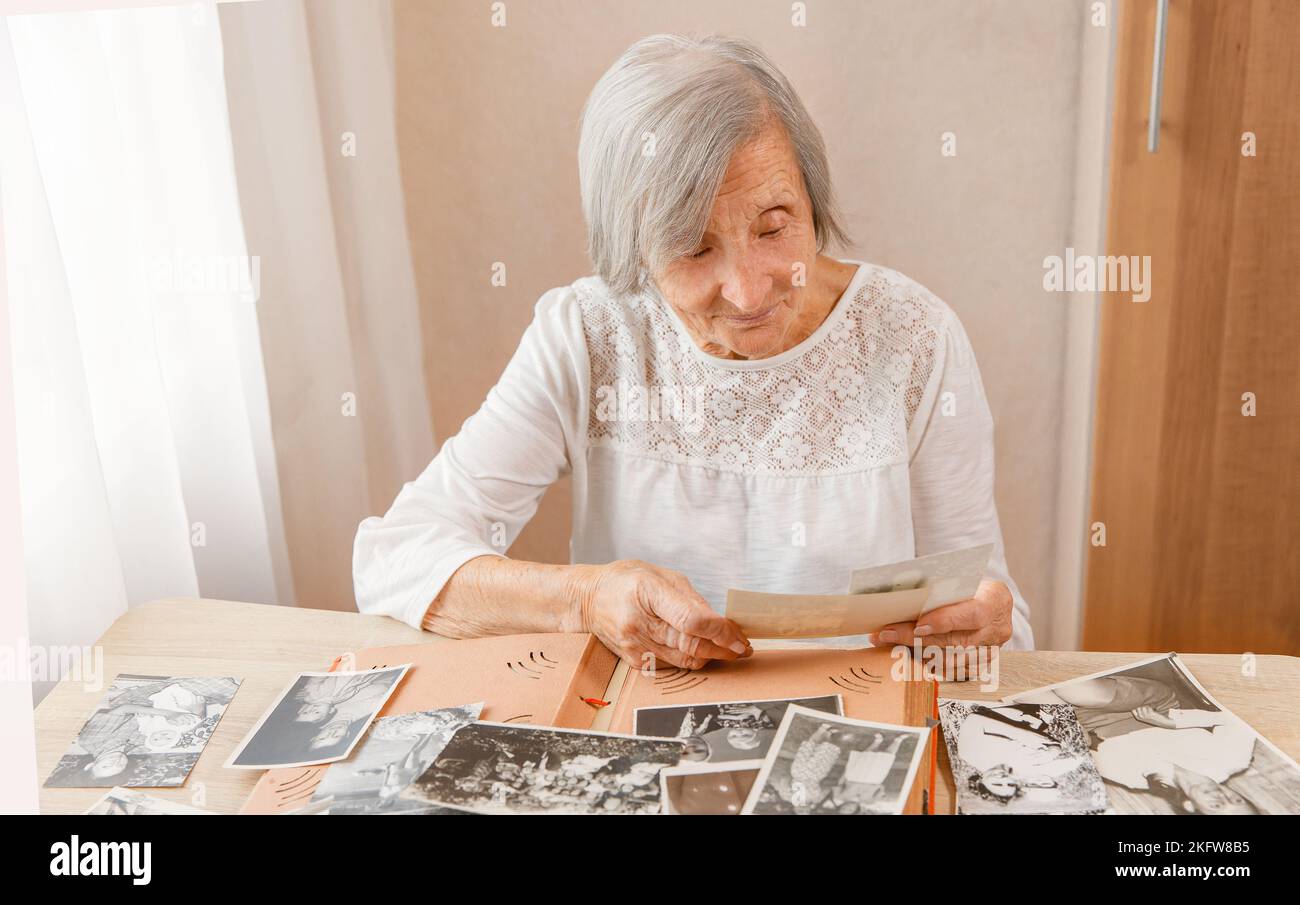 Senior woman is looking old photos Stock Photo - Alamy