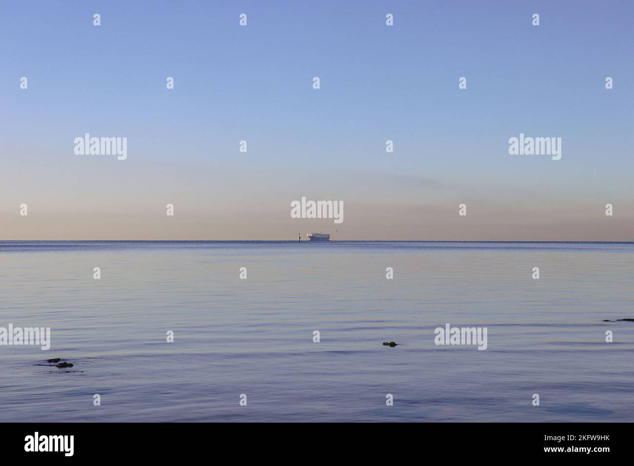 A scenic view of the calm sea at sunset Stock Photo - Alamy