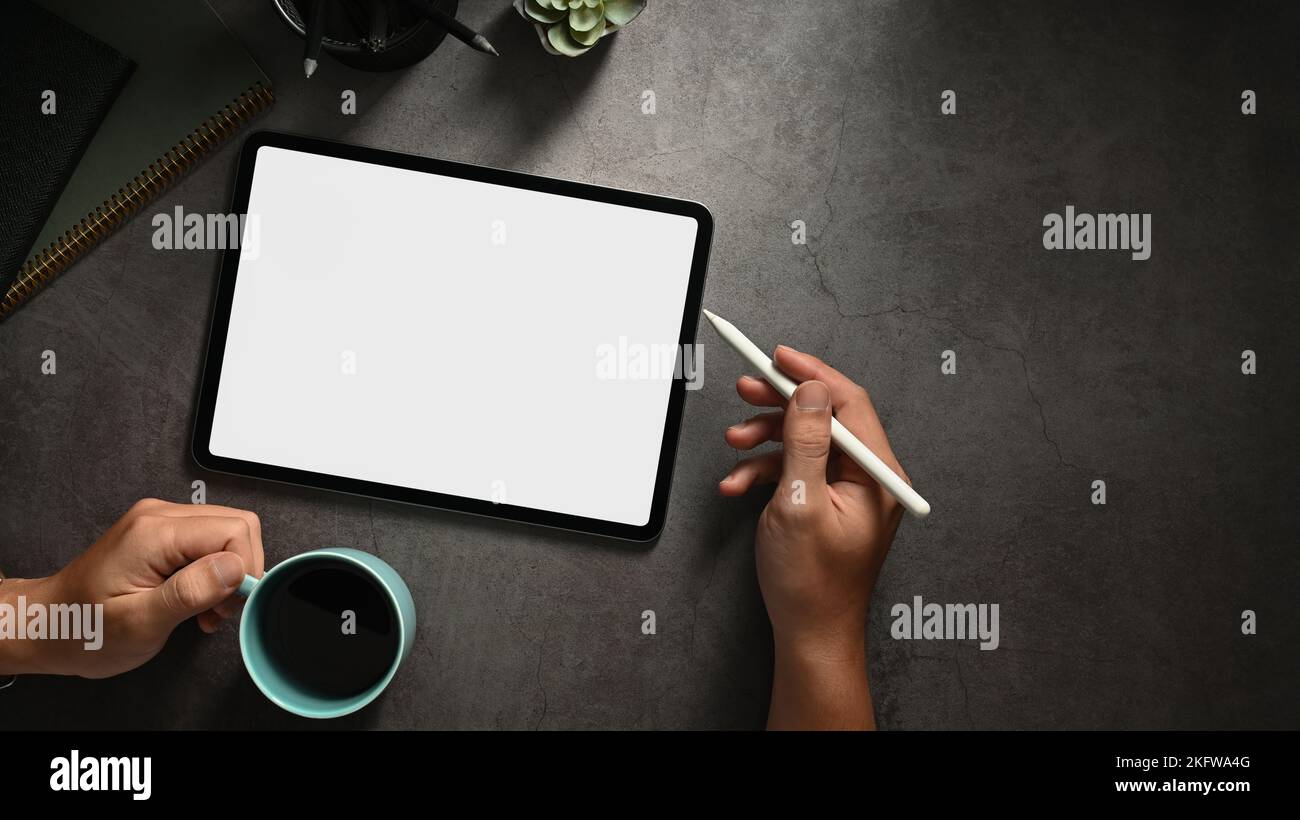 Top view office desk with hands holding digital tablet, empty screen ...