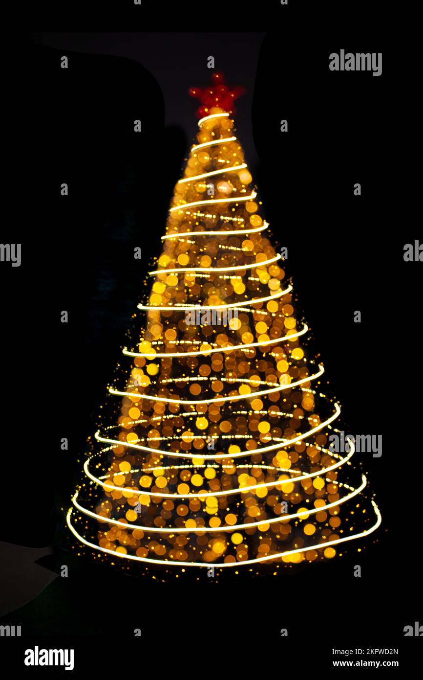Blurred yellow Christmas tree lights with particles and circles on ...