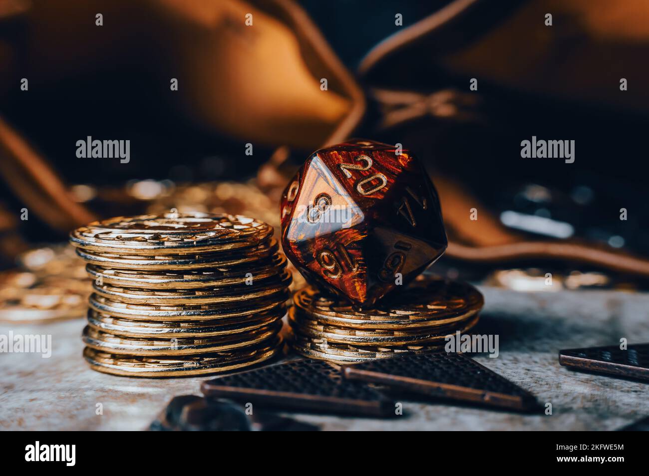 Close-up image of a red Role-playing gaming die on top of golden gaming ...