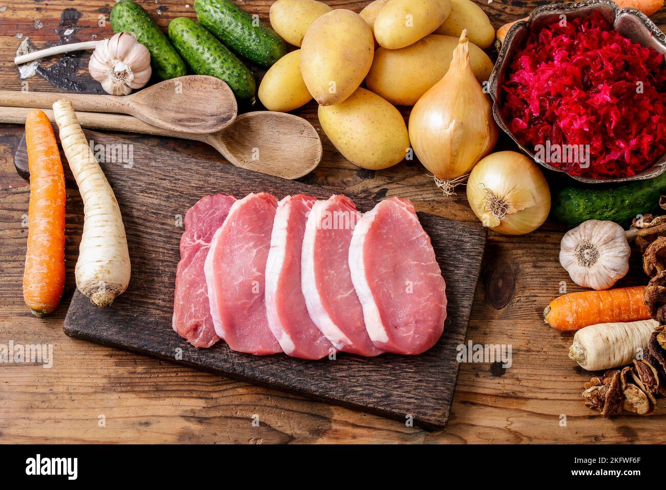 Different kinds of meat and vegetables on wooden table. Cooking time ...