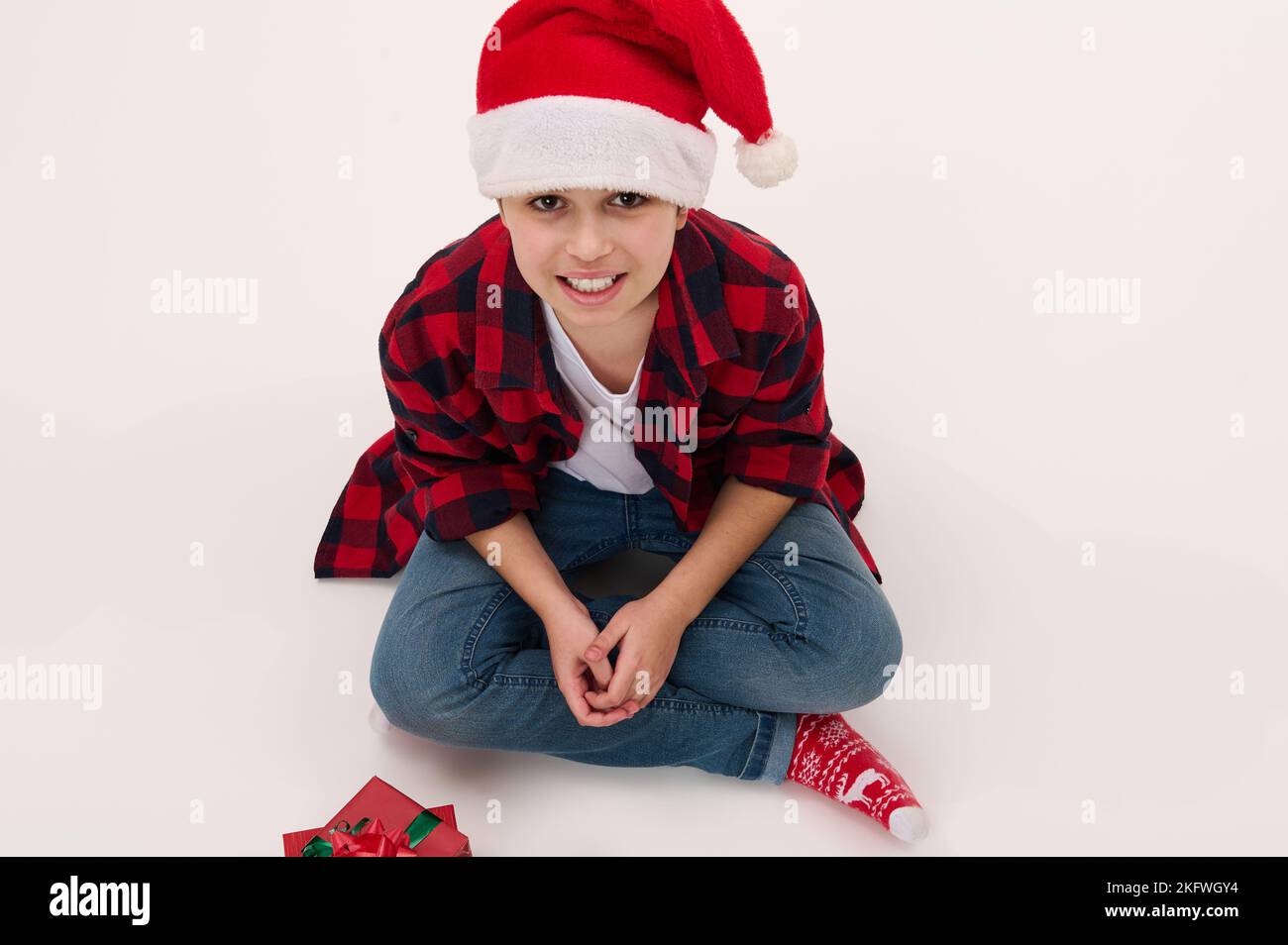 View from above of an adorable preteen boy in Santa hat, sitting on ...