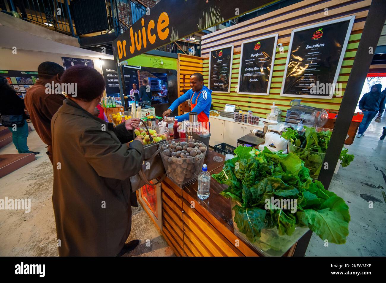 Tourists enjoying snacks at the V & A Foodmarket, V & A Waterfront ...