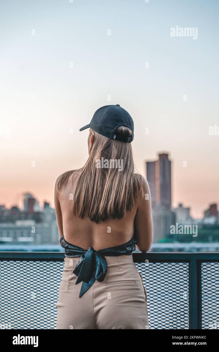 A vertical shot of a young girl on the Brooklyn Bridge in NYC, USA ...