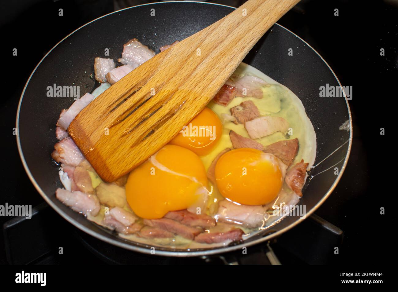 Scrambled eggs with bacon in a pan Stock Photo - Alamy