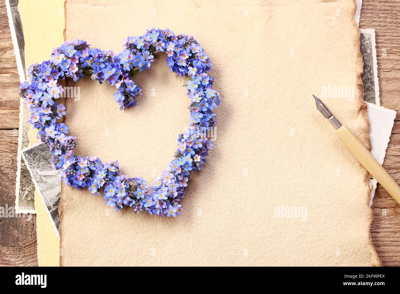 Heart shaped wreath made of forget-me-not flowers. Vintage sheets of ...