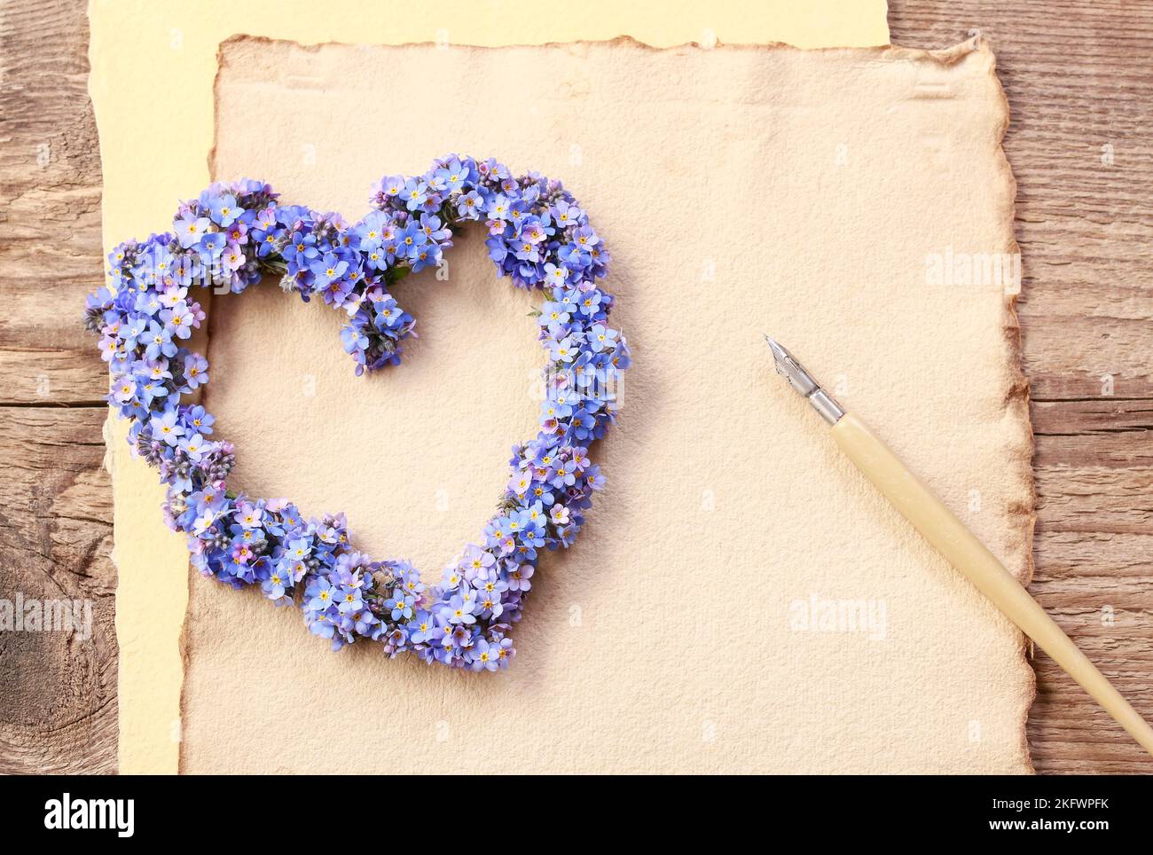 Heart shaped wreath made of forget-me-not flowers. Vintage sheets of ...